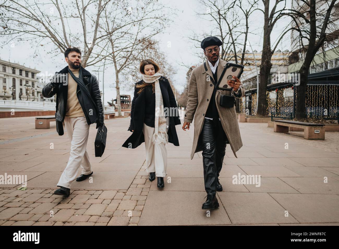 Trendy young business professionals walking in a modern urban setting ...