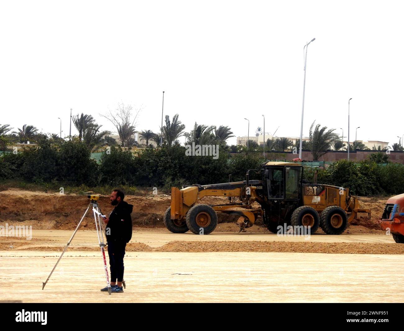 Cairo, Egypt, February 23 2024: An engineer and ground leveling with ...