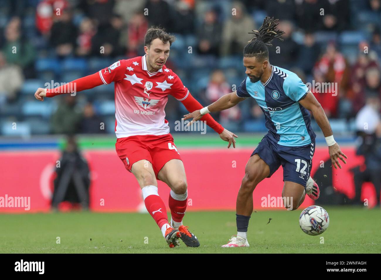 Josh Earl of Barnsley passes the ball under pressure from Garath ...