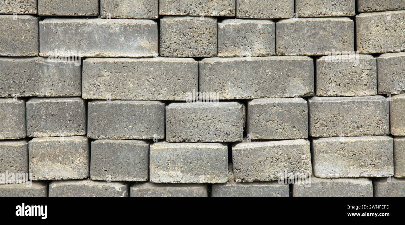 The surface of a wall or fence lined with gray bricks. Paving slabs of ...