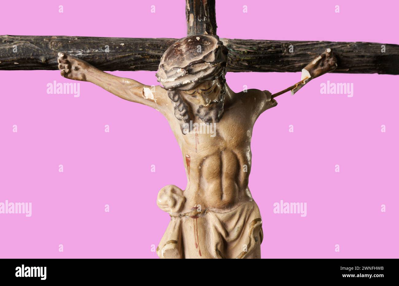 Broken And Dusty Figure Of The Crucified Jesus Christ Against A Pink ...