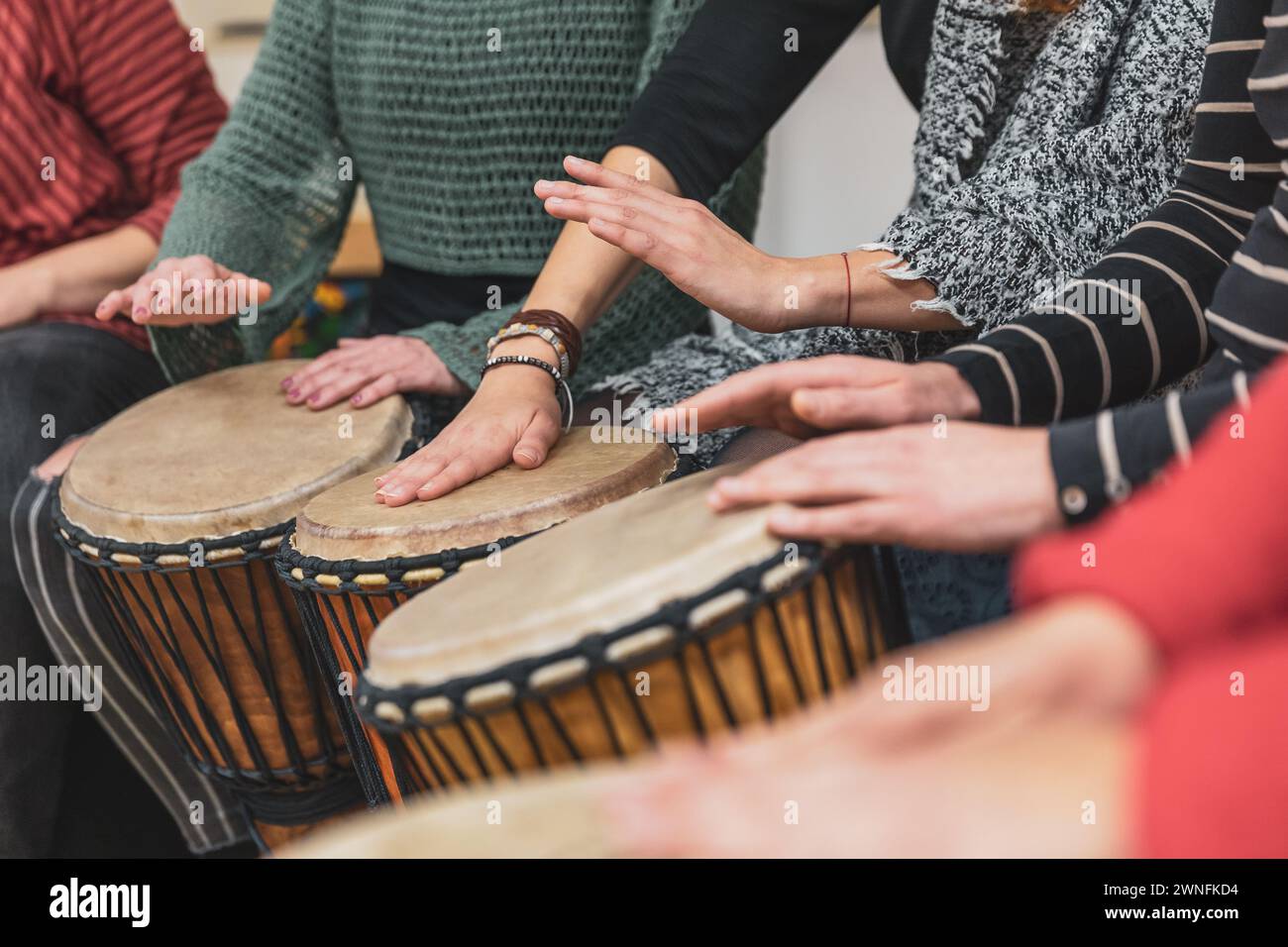 Group of people playing drums during a music therapy lessons, jembe ...
