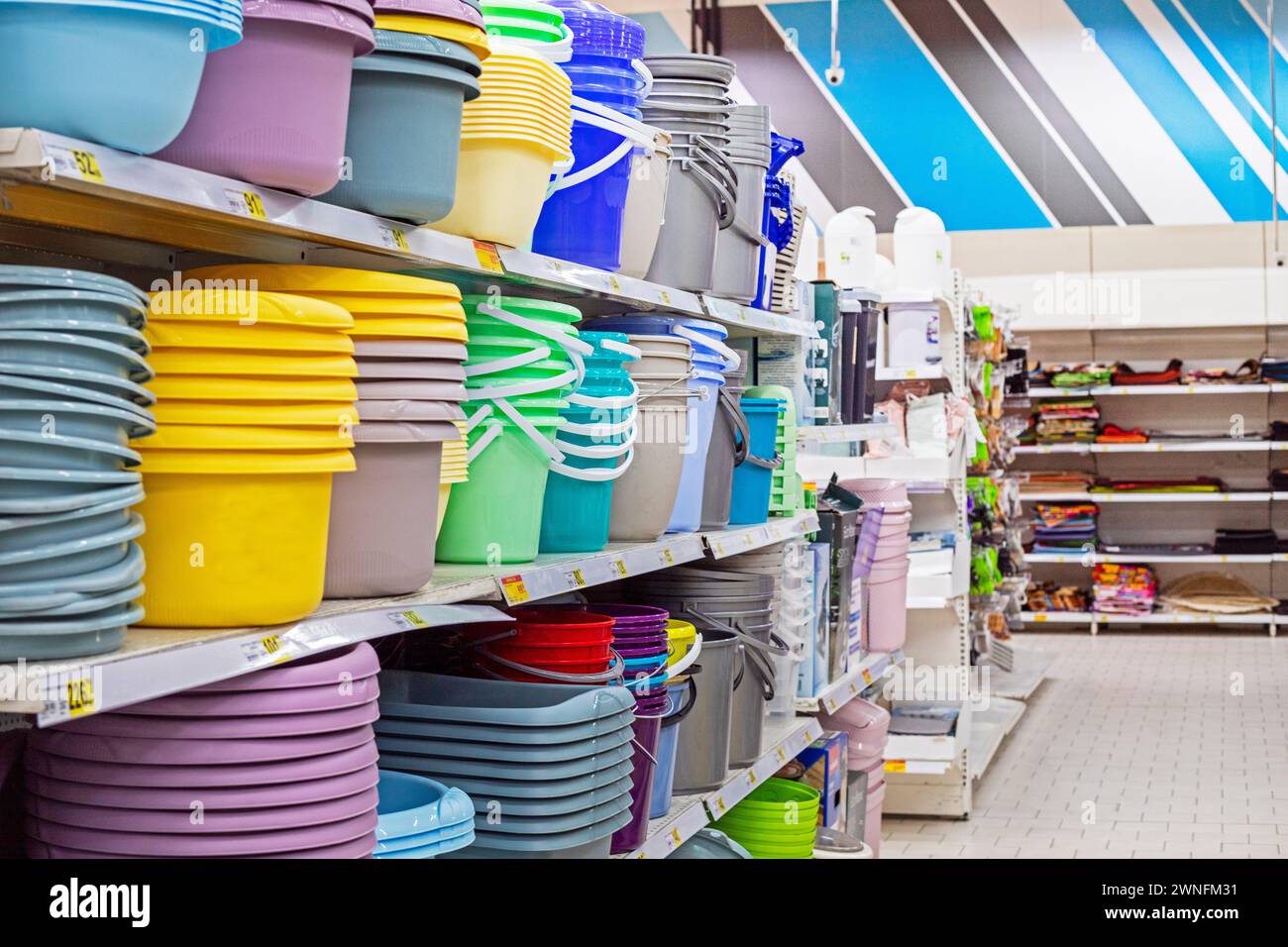 colorful plastic basins and buckets on the counter in a supermarket ...