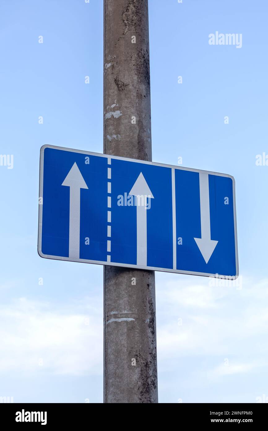Road sign with arrows on blue sky background close up Stock Photo - Alamy