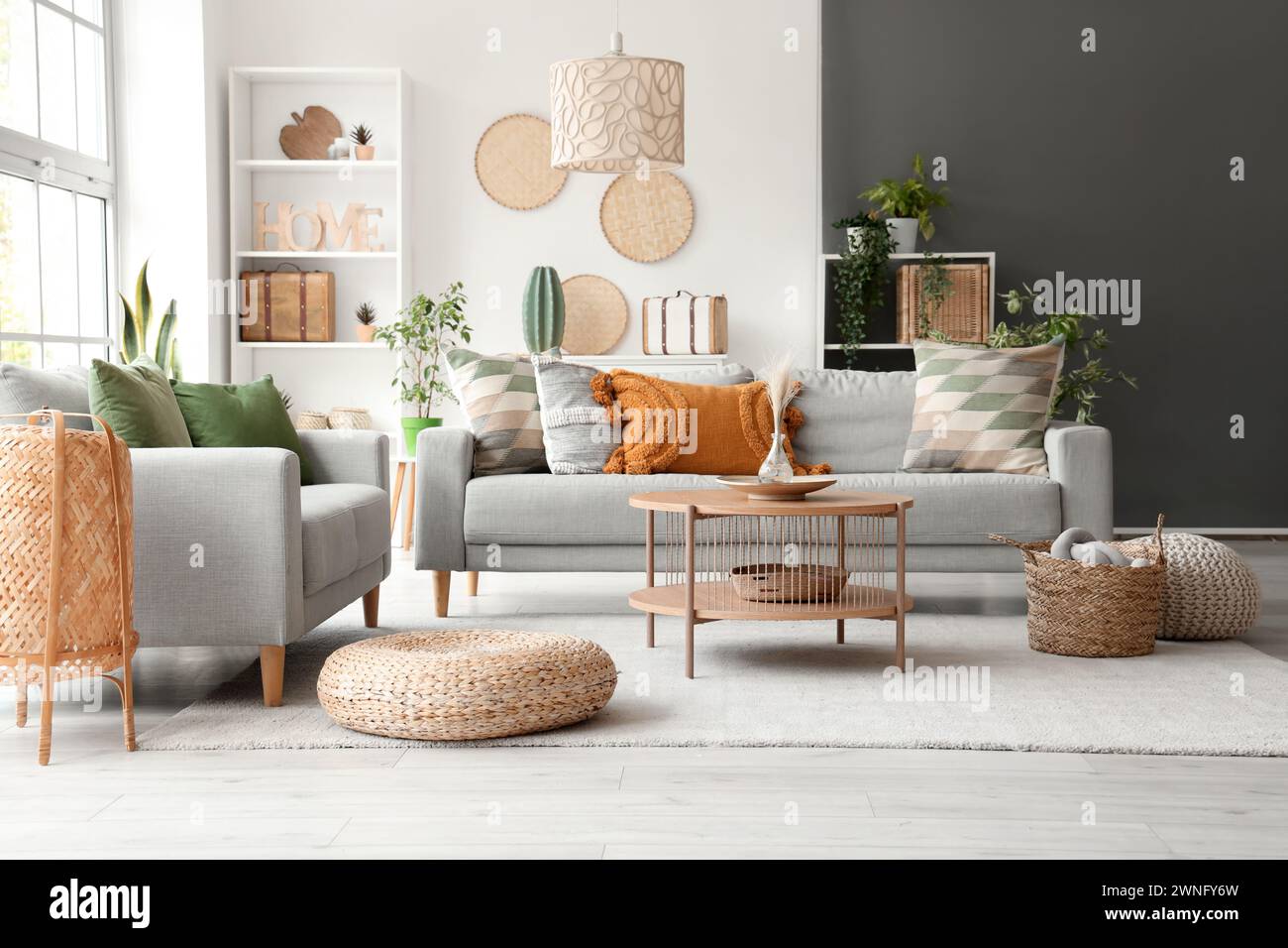 Interior of light living room with grey sofas, coffee table and wicker ...