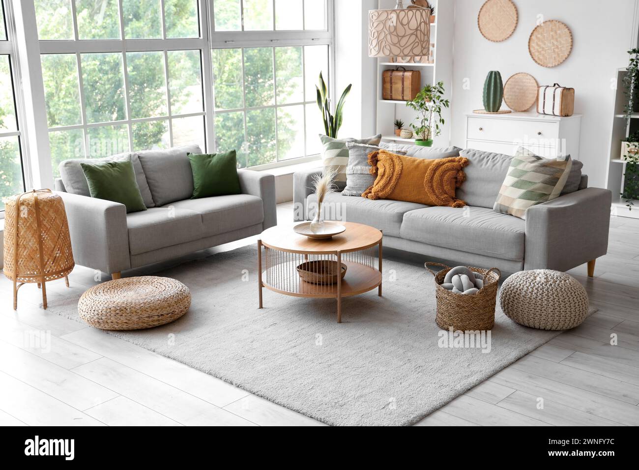 Interior of light living room with grey sofas, coffee table and wicker ...