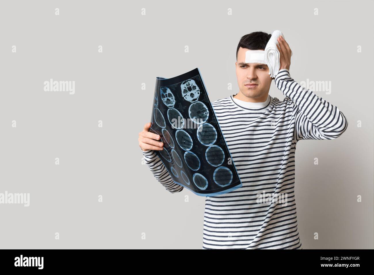 Young man with brain concussion and MRI scan on light background Stock ...