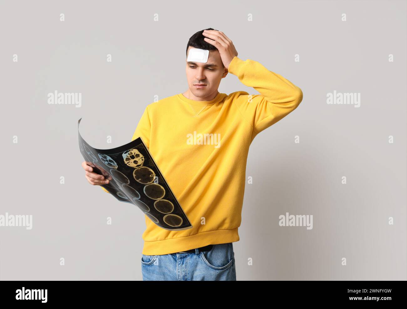 Young man with brain concussion and MRI scan on light background Stock ...