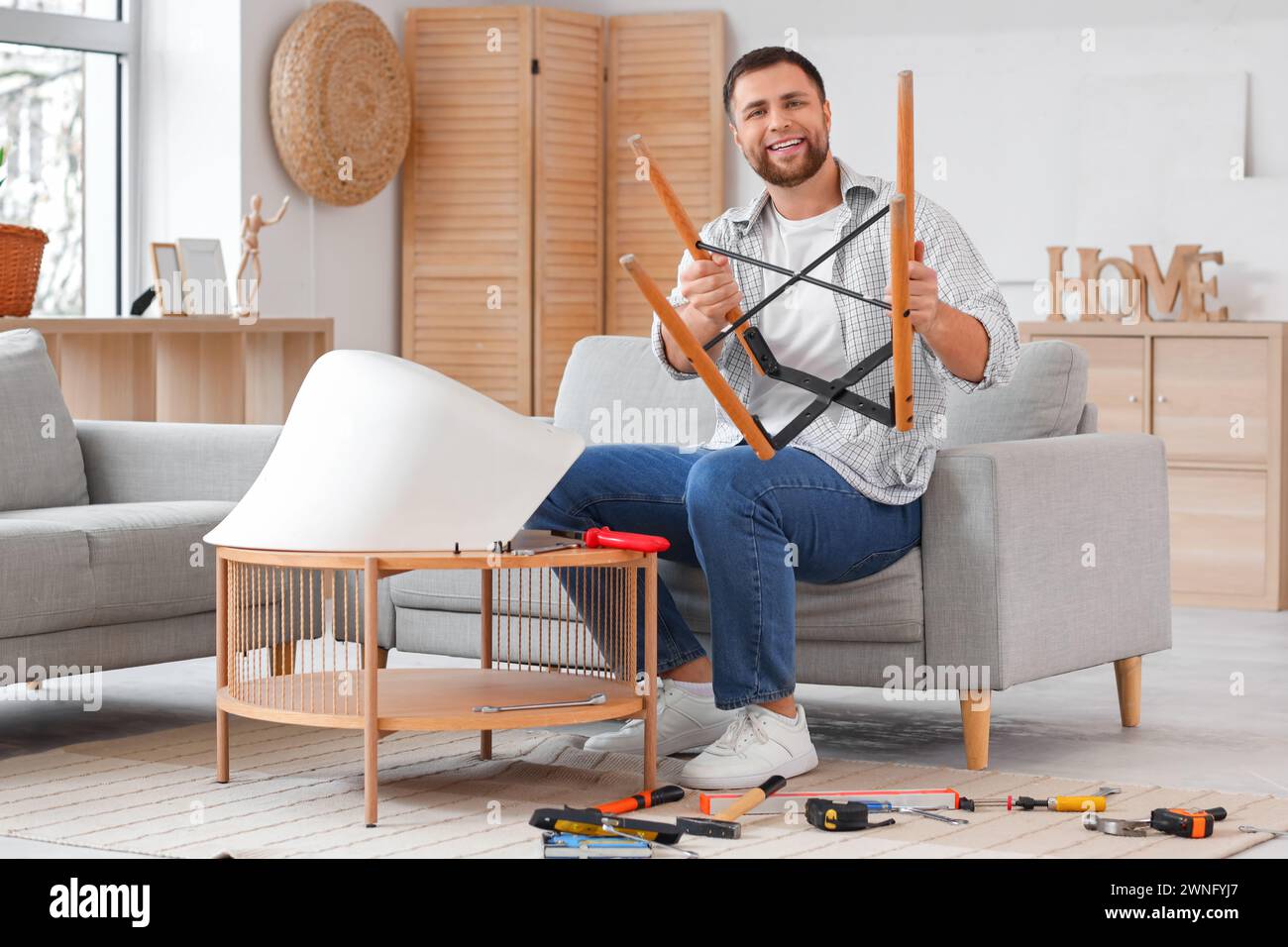 Young man assembling chair at home Stock Photo - Alamy