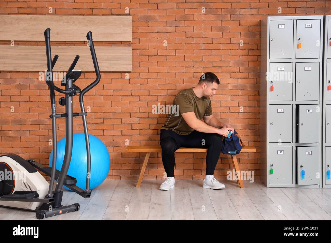 Sporty young man taking inhaler from bag in gym Stock Photo - Alamy