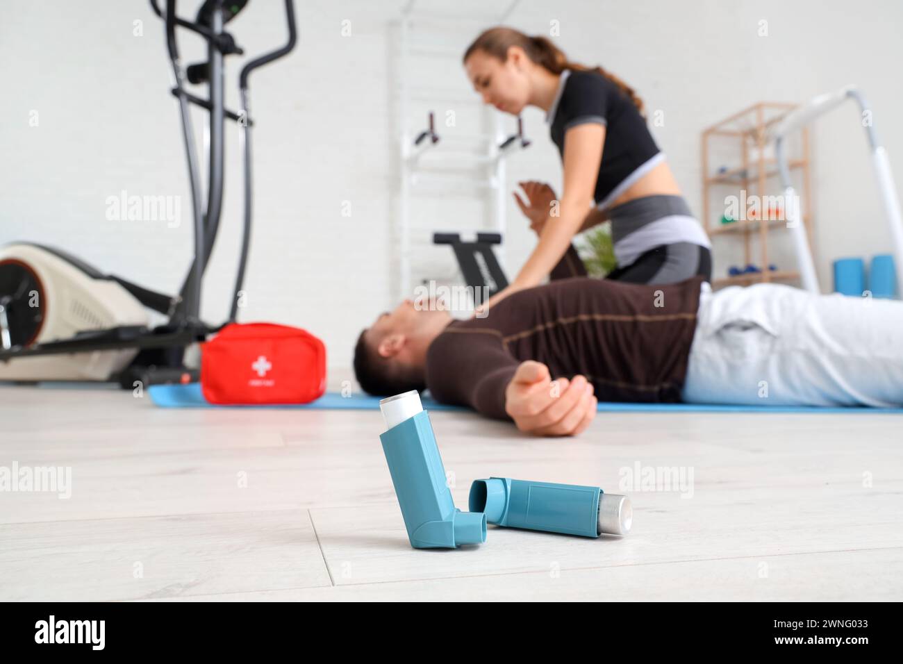 Asthma inhalers and trainer giving man first aid in gym, closeup Stock ...