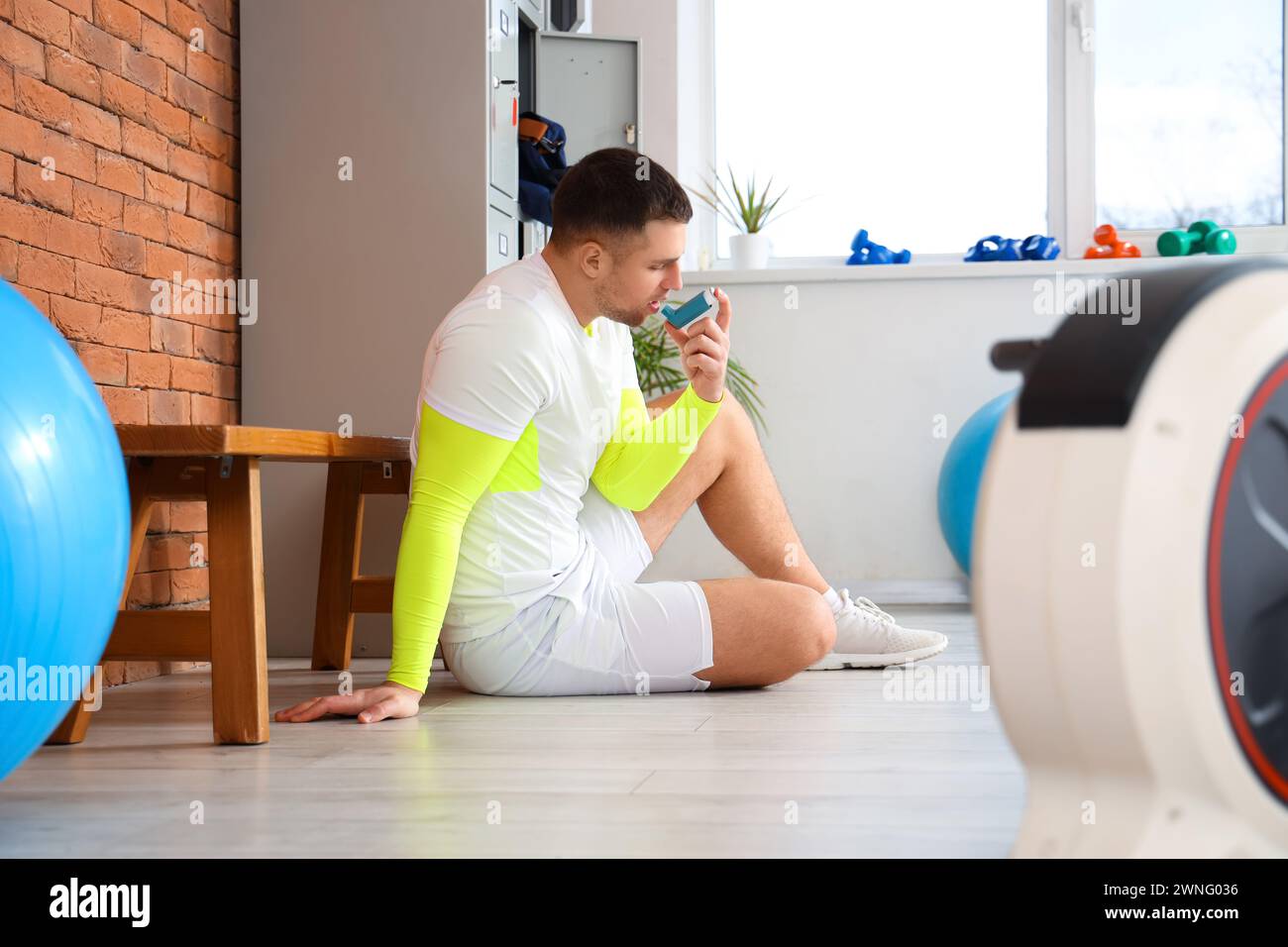 Sporty young man with asthma attack using inhaler in gym Stock Photo ...
