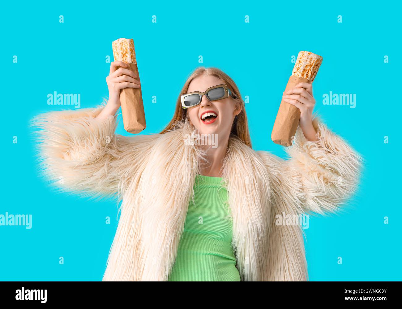 Stylish young woman with doner kebabs on blue background Stock Photo ...