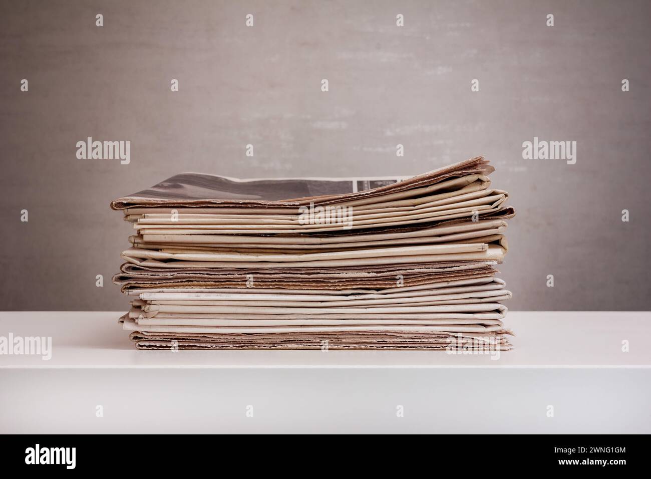 a stack of newspapers on a white table on a grey background Stock Photo ...