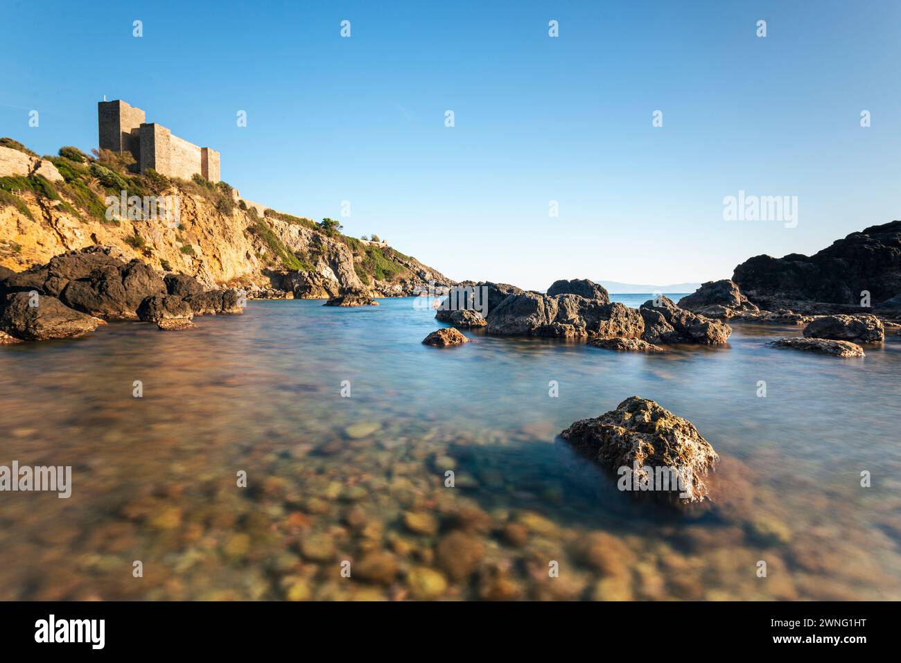 The Rocca Aldobrandesca castle on the rocky coast of the Maremma in ...