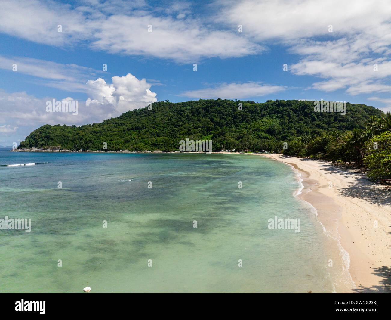 Ocean waves on sandy beach with clear turquoise water. Blue sky and ...
