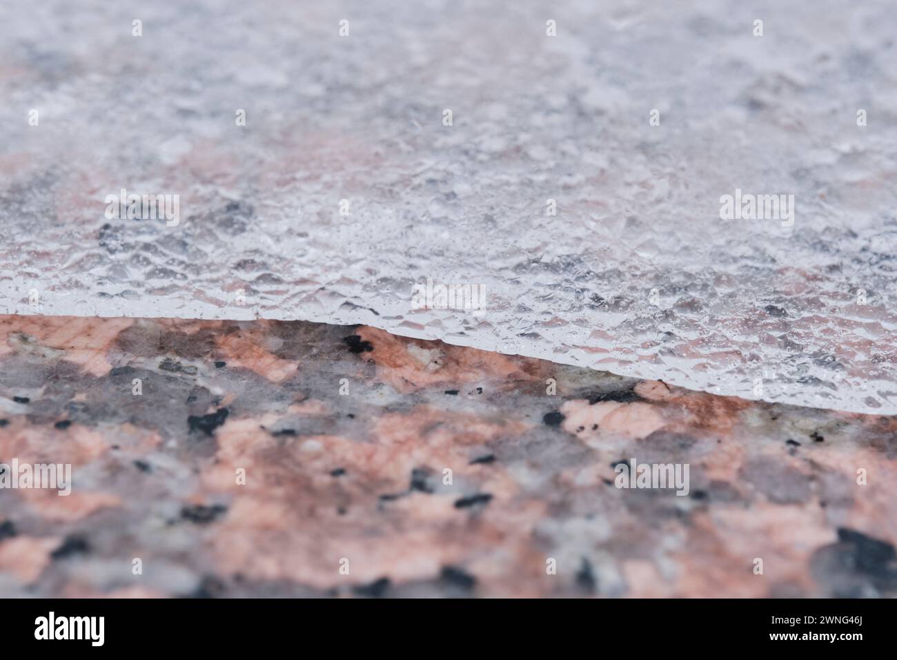 Melting ice partially covers granite tiles Stock Photo - Alamy