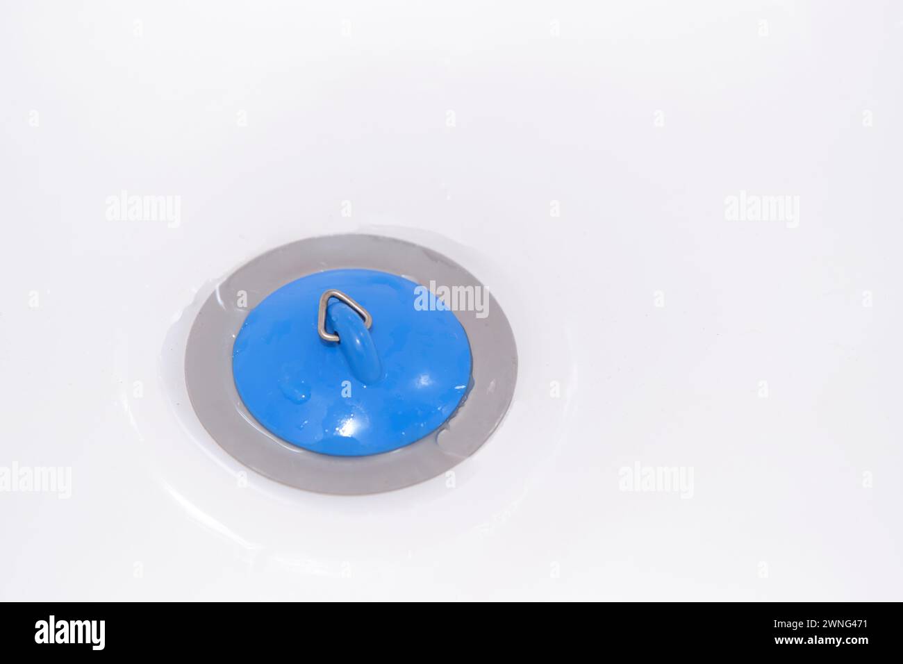 Bathroom drain is closed with blue plug Stock Photo - Alamy