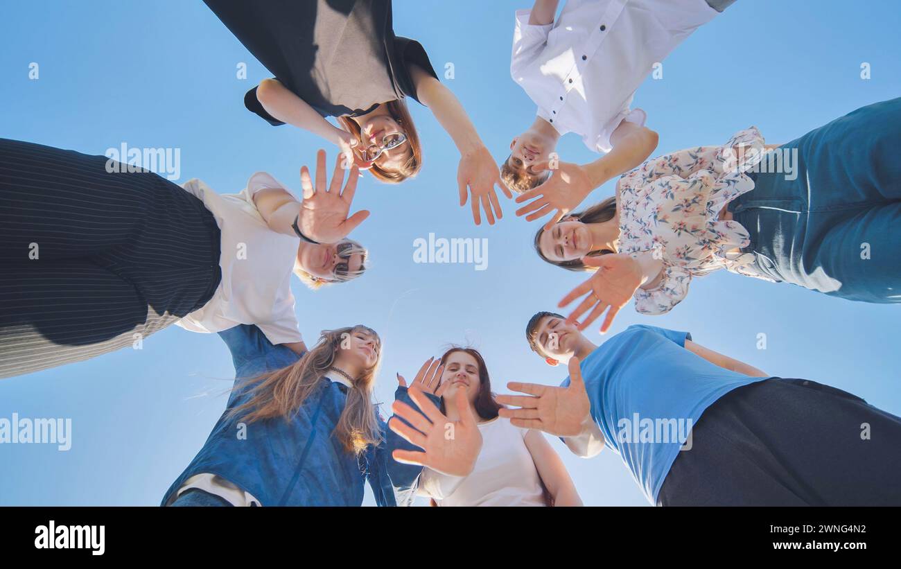 The young friends stand in a circle and wave their hands Stock Photo ...