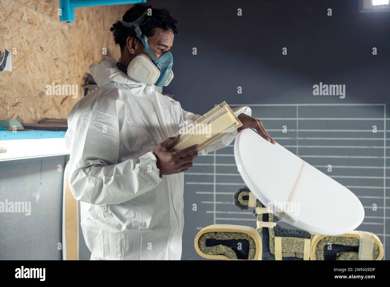 Surfboard manufacturing, Shaper working on board details. Concept of ...