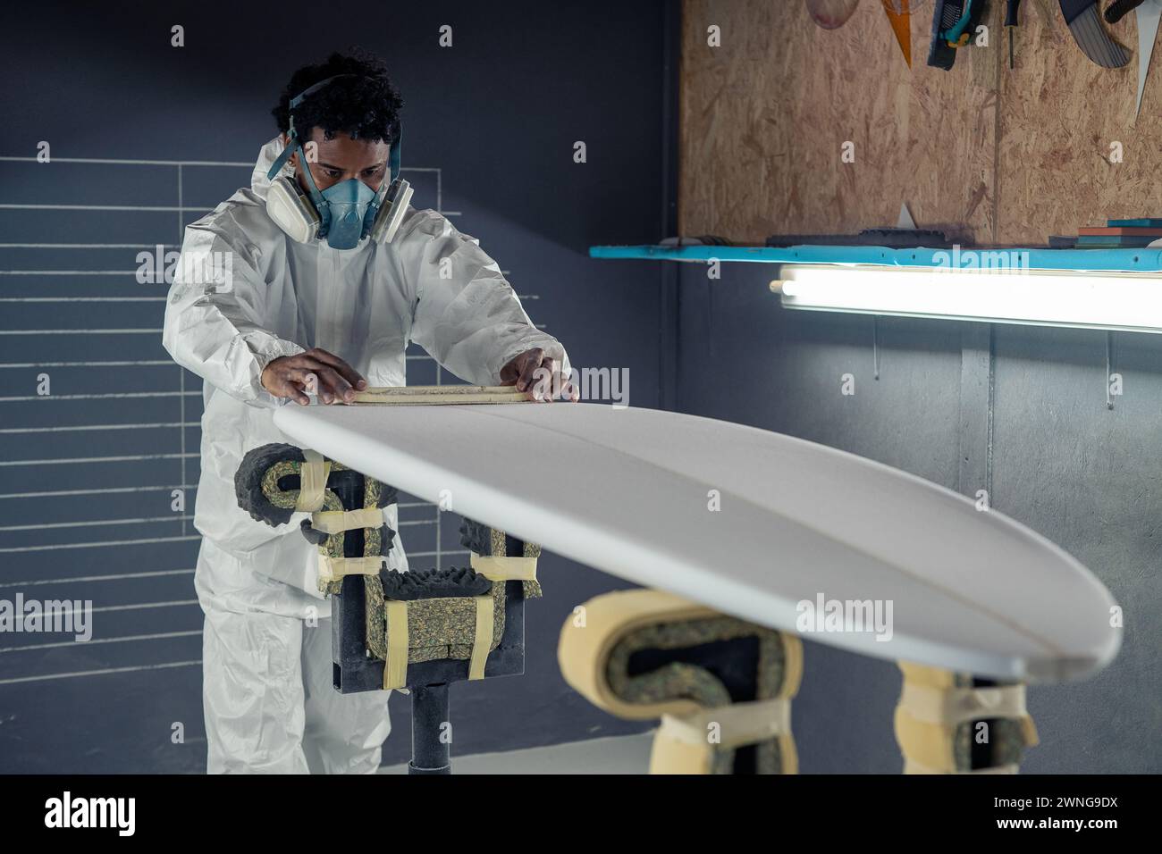 Surfboard manufacturing, Shaper working on board details. Concept of ...