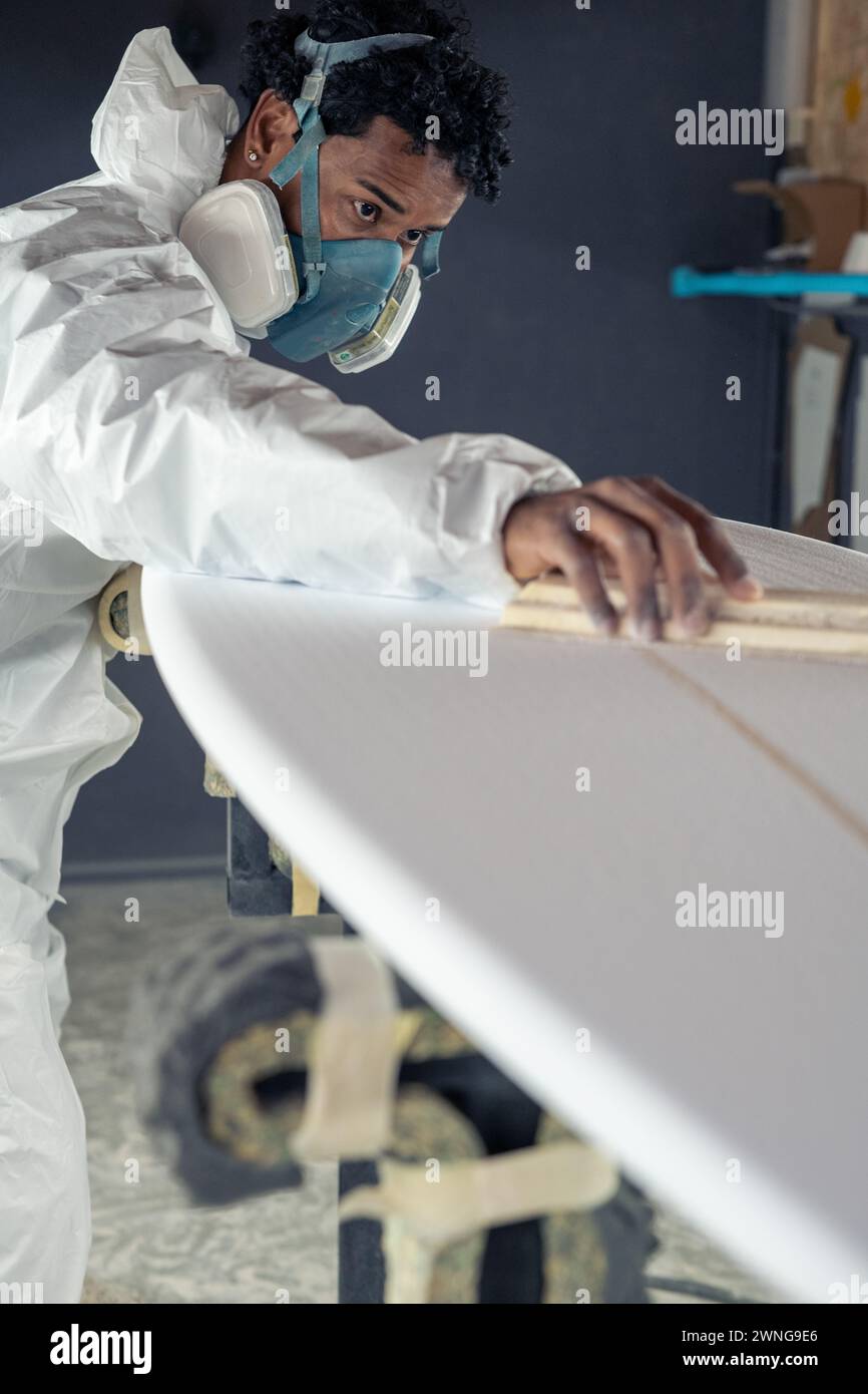 Surfboard manufacturing, Shaper working on board details. Concept of ...