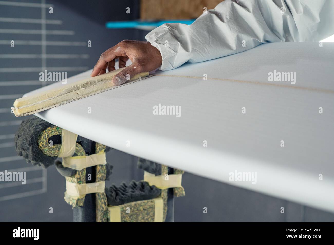 Surfboard manufacturing, Shaper working on board details. Concept of ...