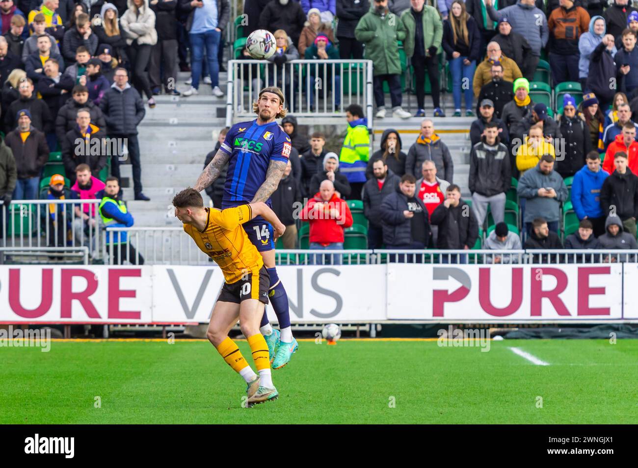 Aden Flint of Mansfield Town competes for a header with Seb Palmer ...