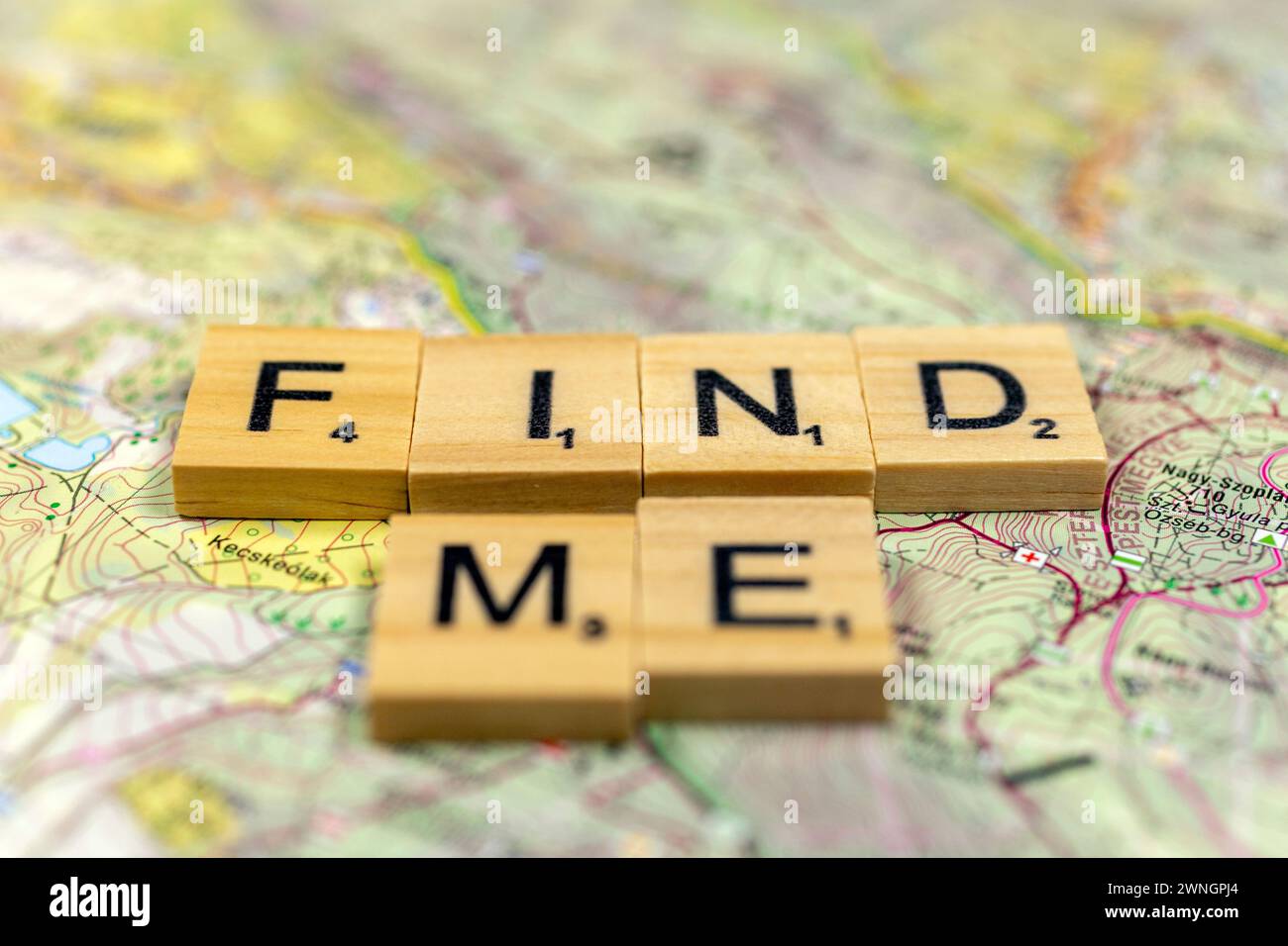 "Find me" wooden letters on an old paper map Stock Photo - Alamy