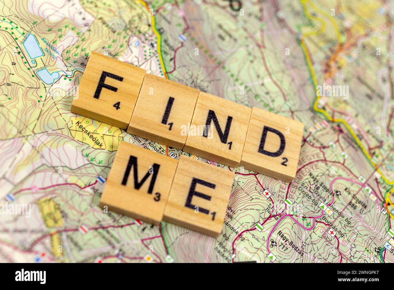"Find me" wooden letters on an old paper map Stock Photo - Alamy