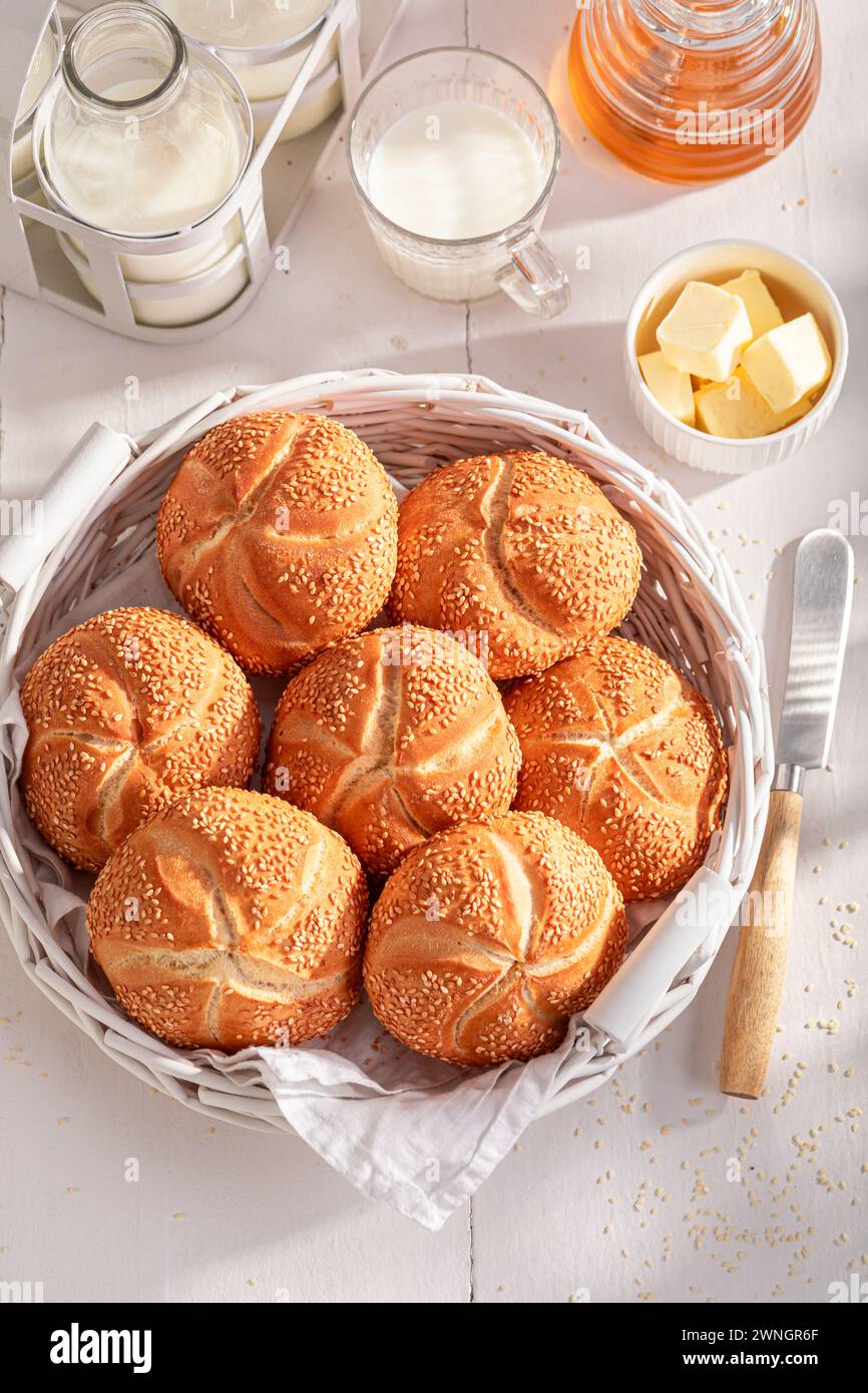 Homemade Kaiser rolls with sesame seeds served with drink. Breakfast ...