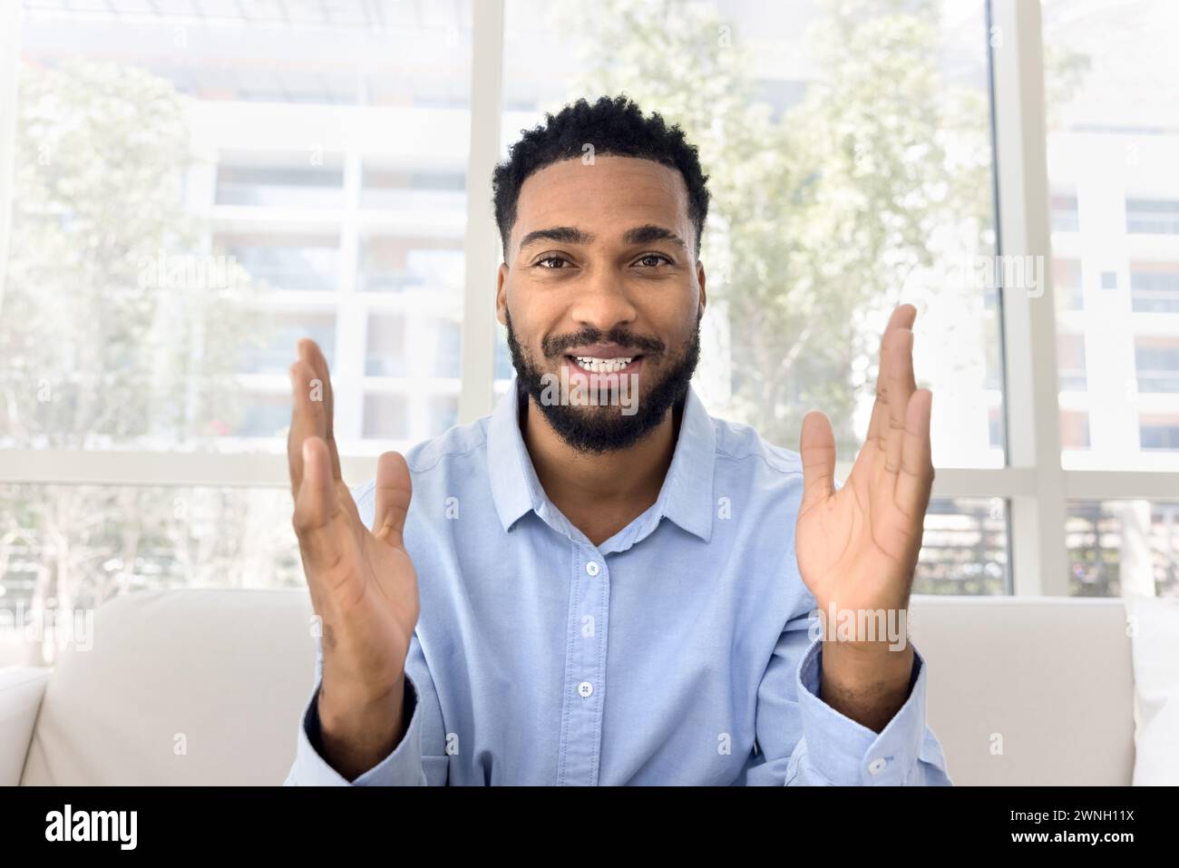 Positive attractive African influencer guy speaking at camera Stock ...