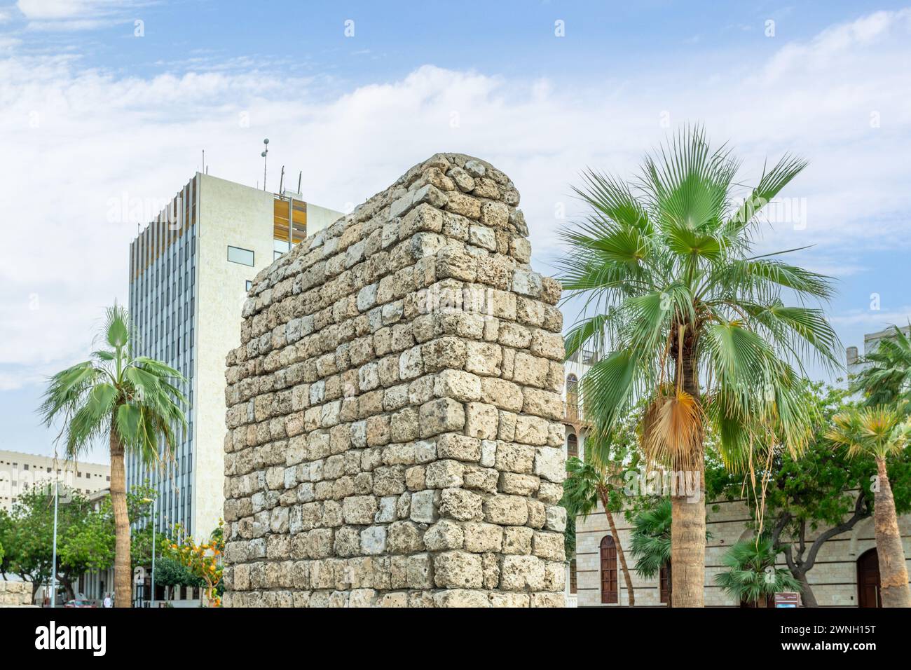 Stone ruins of old arab buildings with palms on the street of Al-Balad ...