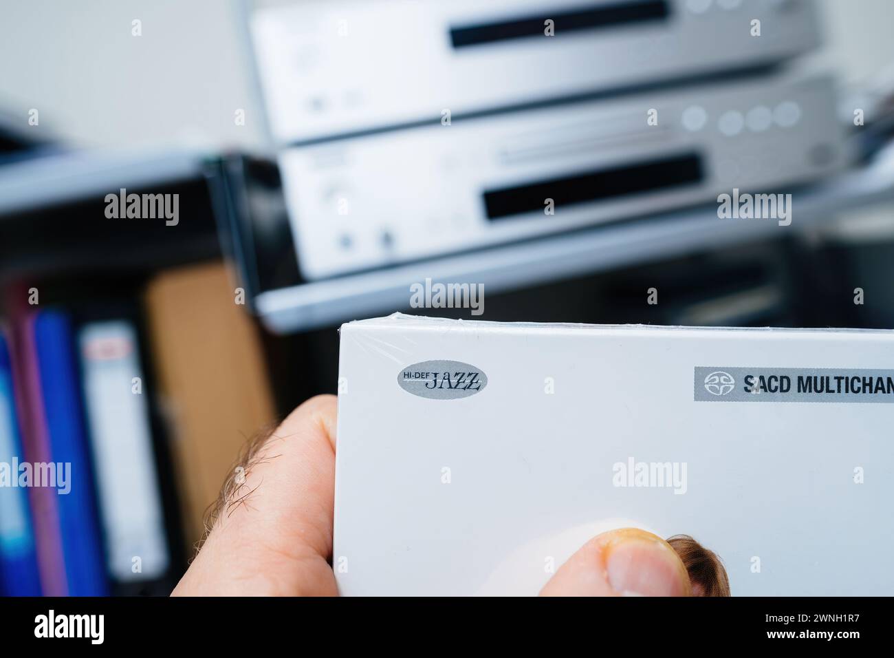 A POV shot features a male hand holding a new SACD package adorned with ...