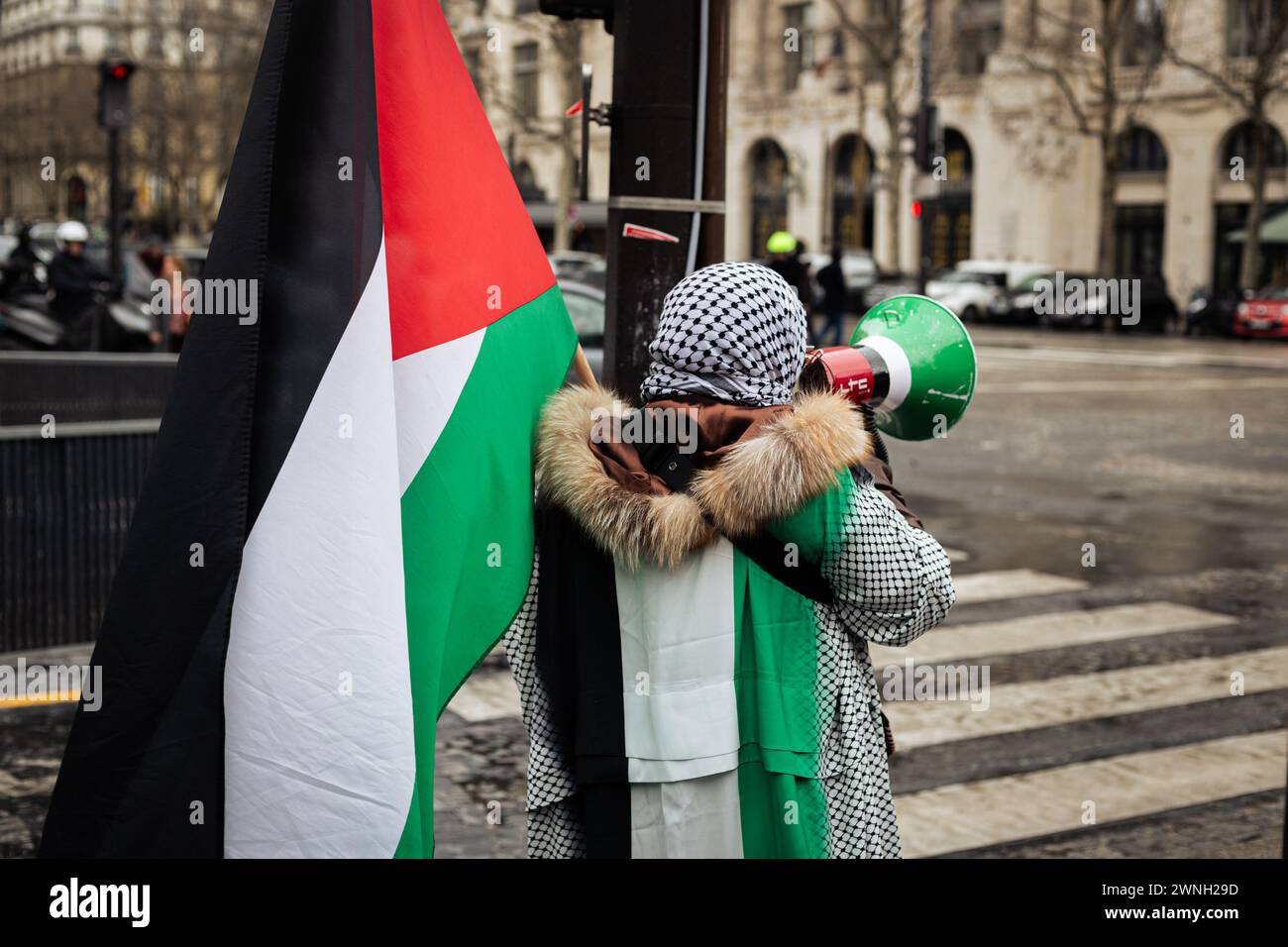 A woman with Palestinian flag chants slogans through megaphone during ...