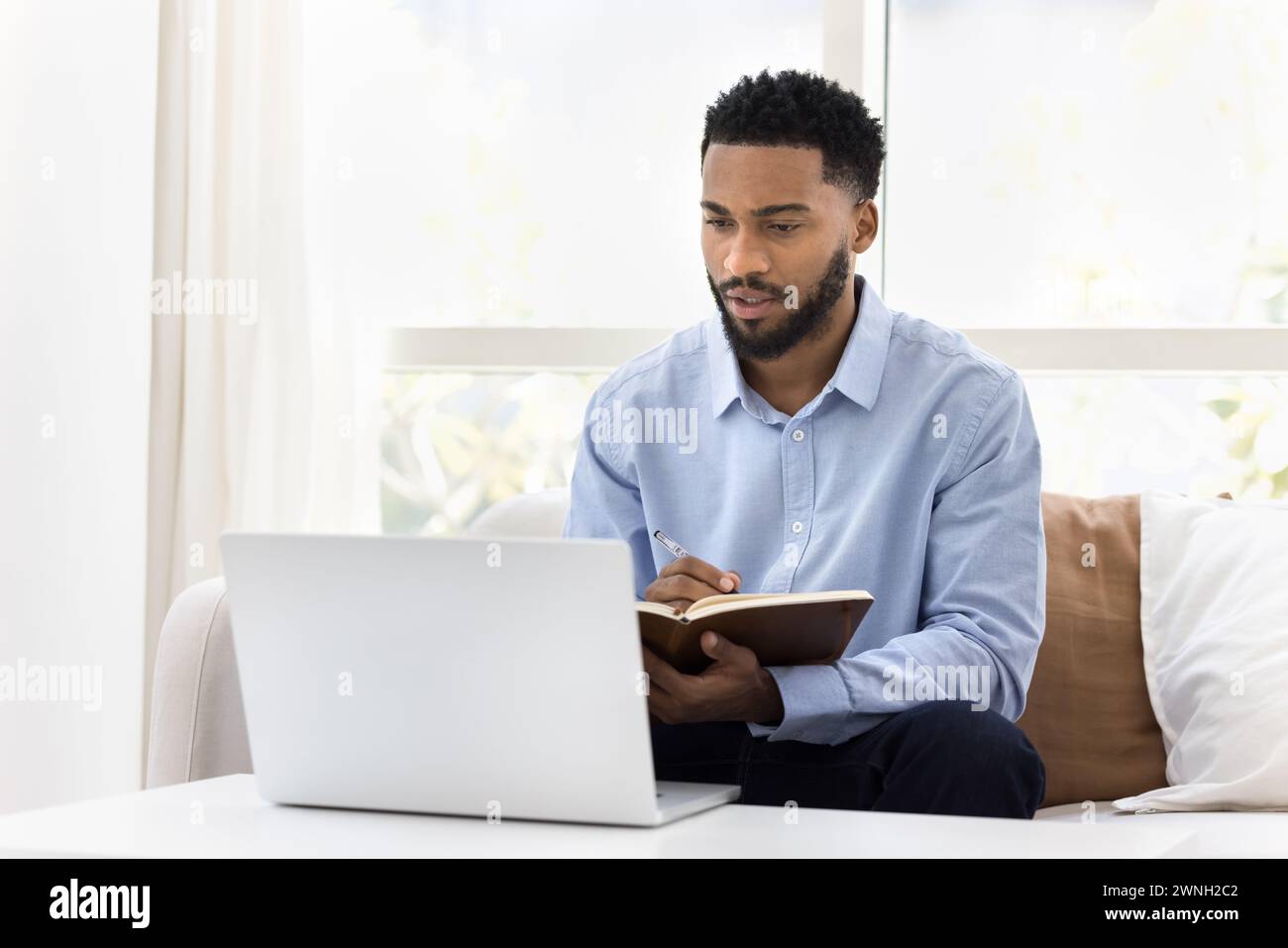 Serious African student man watching online lecture, training seminar ...