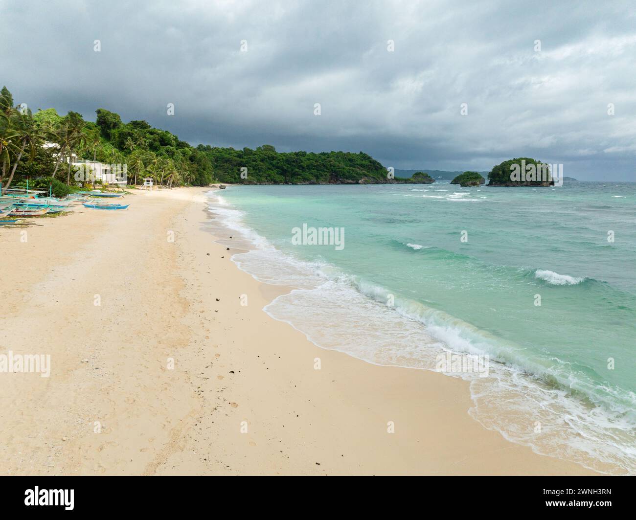 Inshore ocean waves crashing on white sand in Ilig Iligan Beach ...