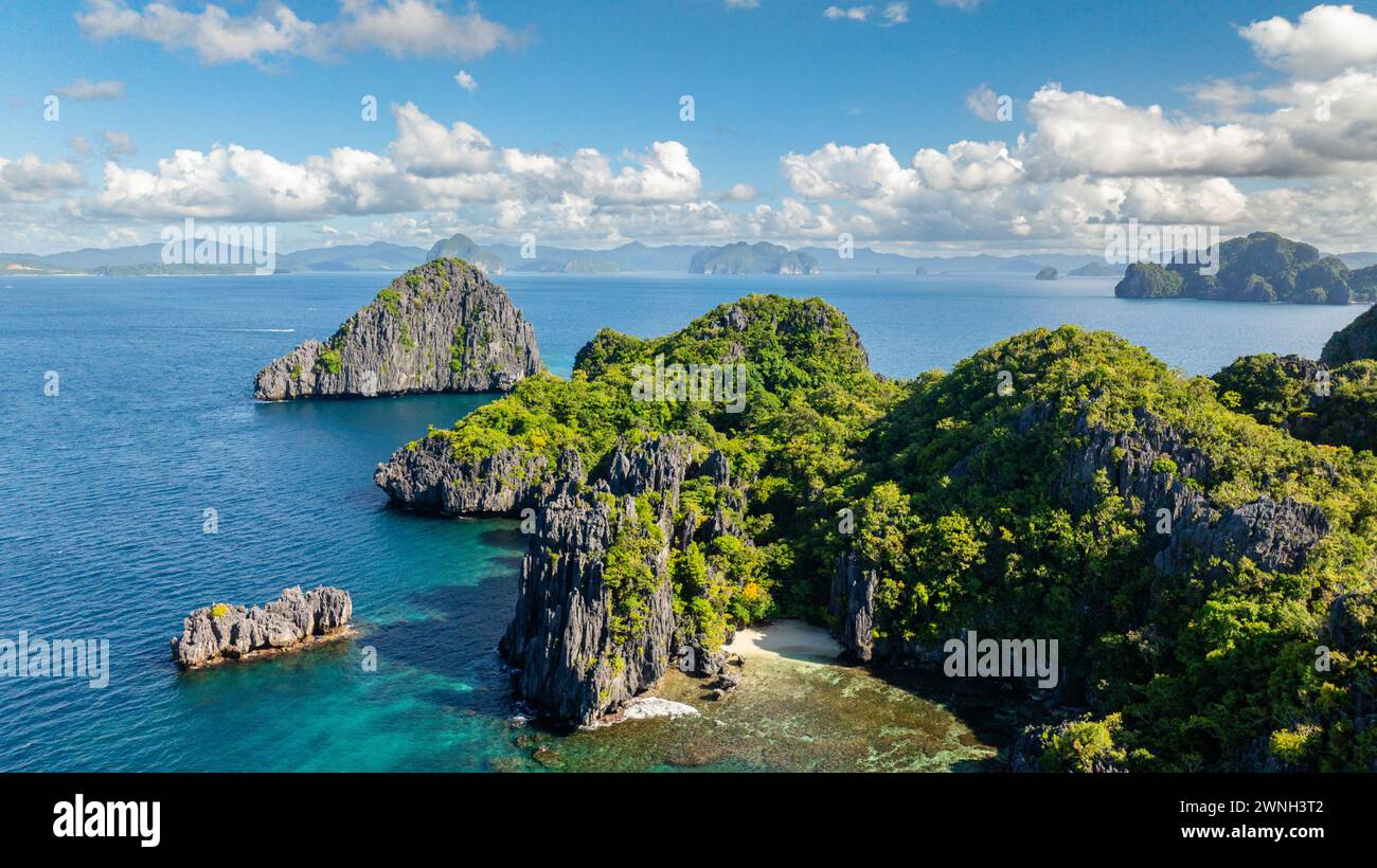 Islets and beach in Miniloc Island. Blue sky and clouds. El Nido ...