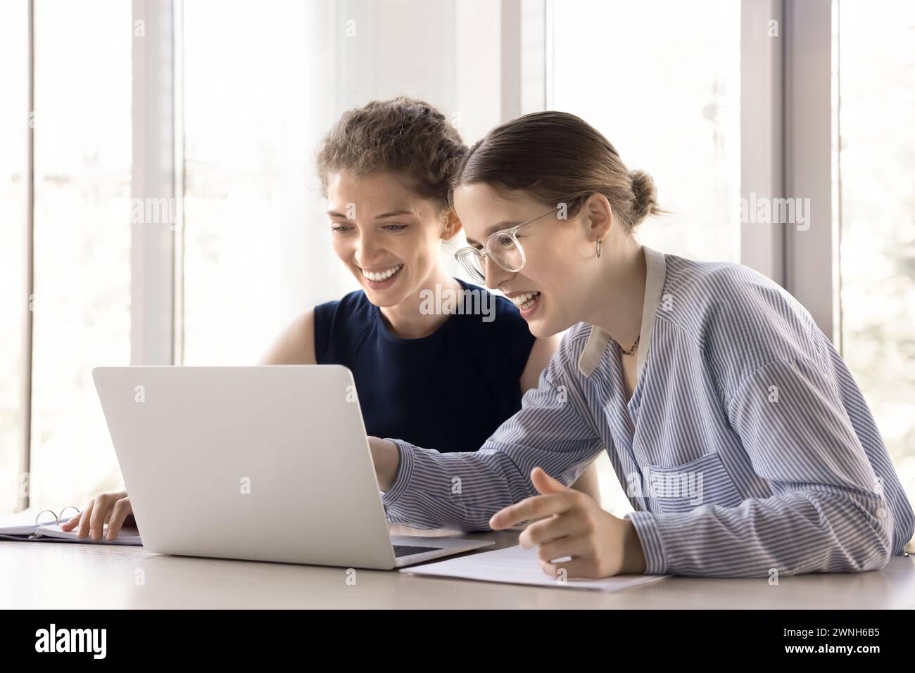 Two happy women colleagues, talking, working together on collaborative ...