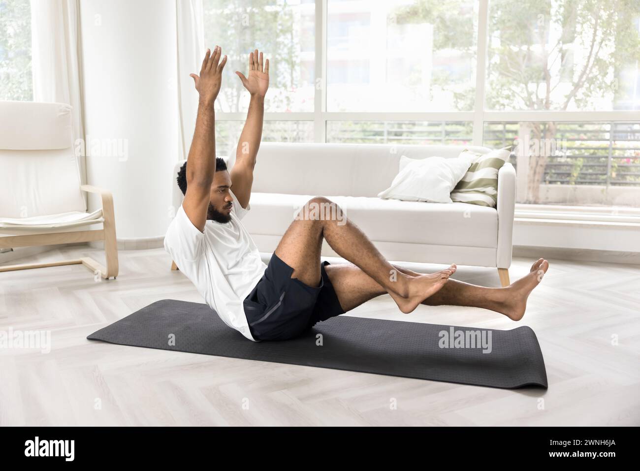Concentrated athletic Black man training strong body at home Stock ...