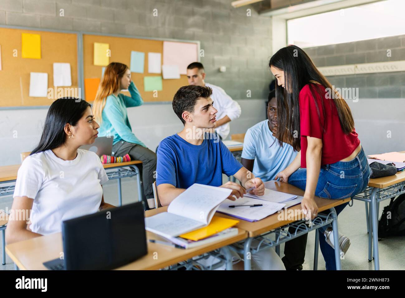 Multiracial young group of students talking during class break at high ...