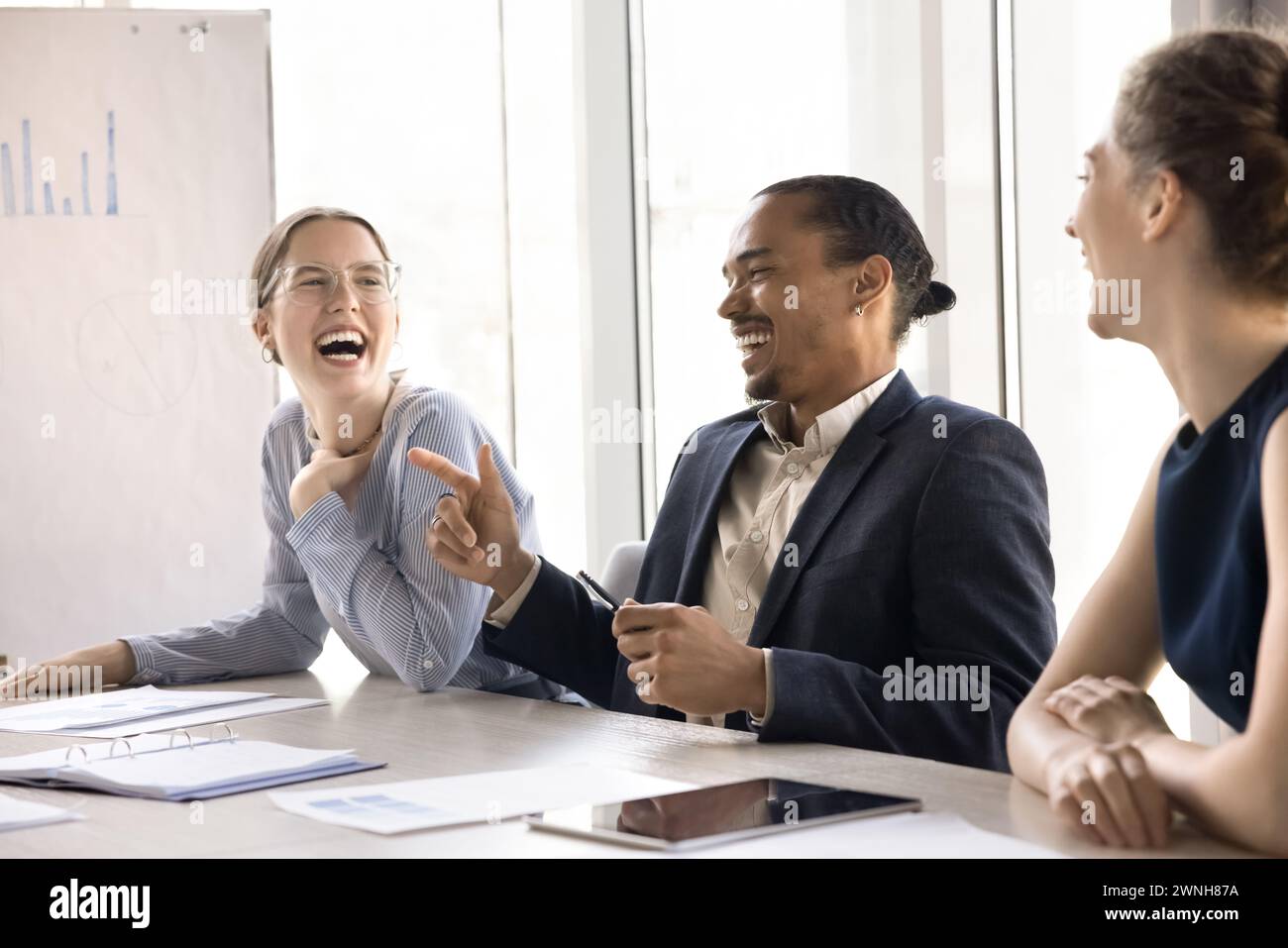 Laughing workmates enjoy briefing in conference room Stock Photo - Alamy