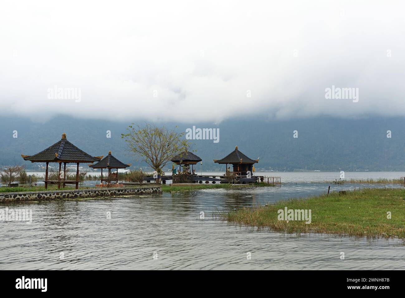 Traditional gazebos on the Bratan mountain lake in cloudy weather on ...
