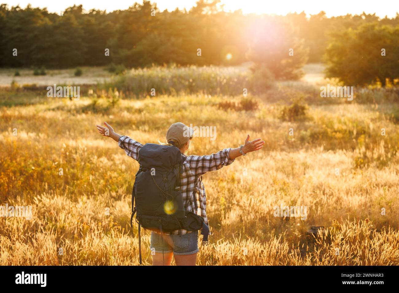 Happy solo hiker enjoying sunset during trekking in nature. Woman with ...