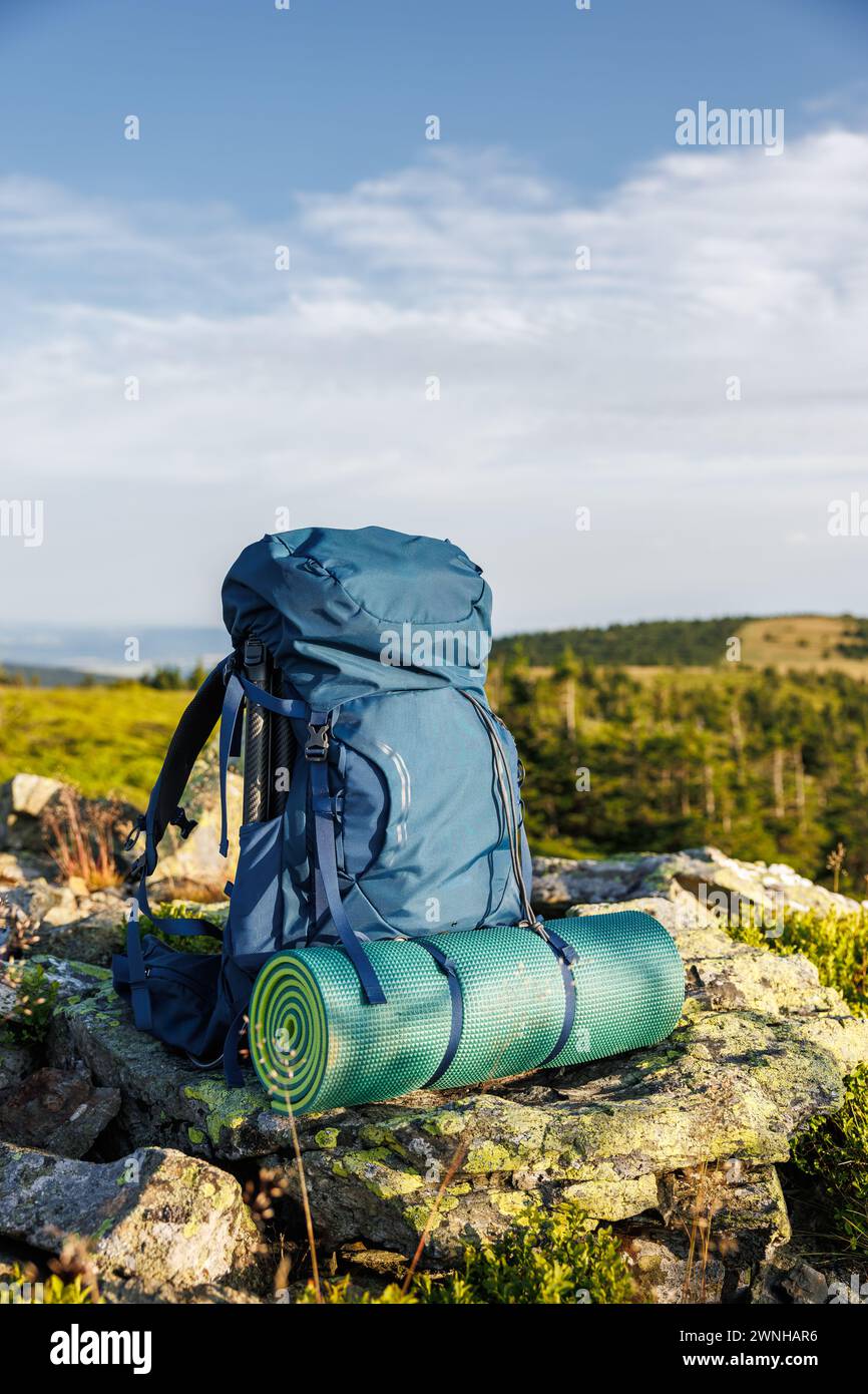 Hiking backpack with mat on rock during trek in mountains. Camping and ...