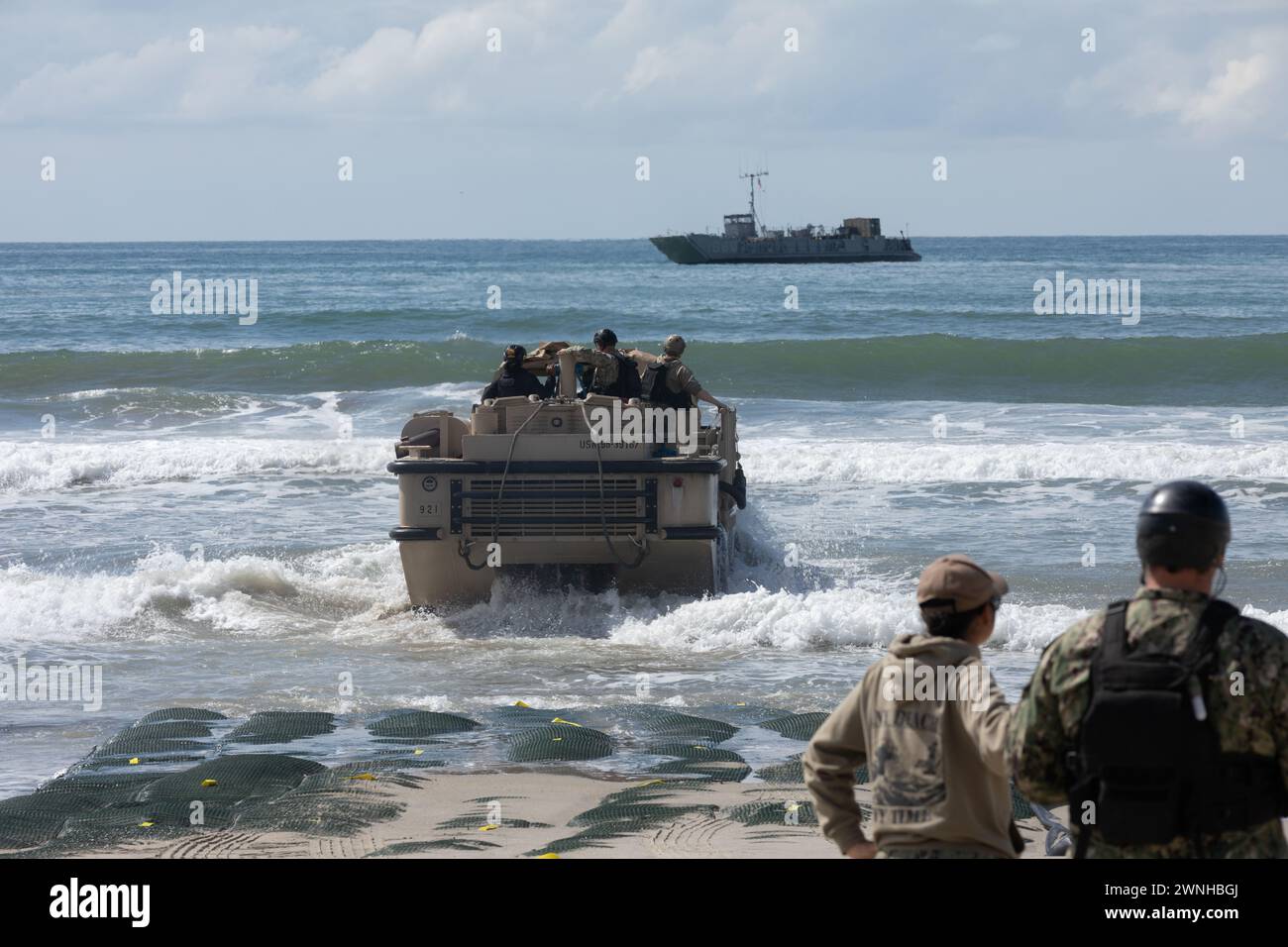 U.S. Navy Sailors, assigned to Beachmaster Unit 1, ground guide a ...