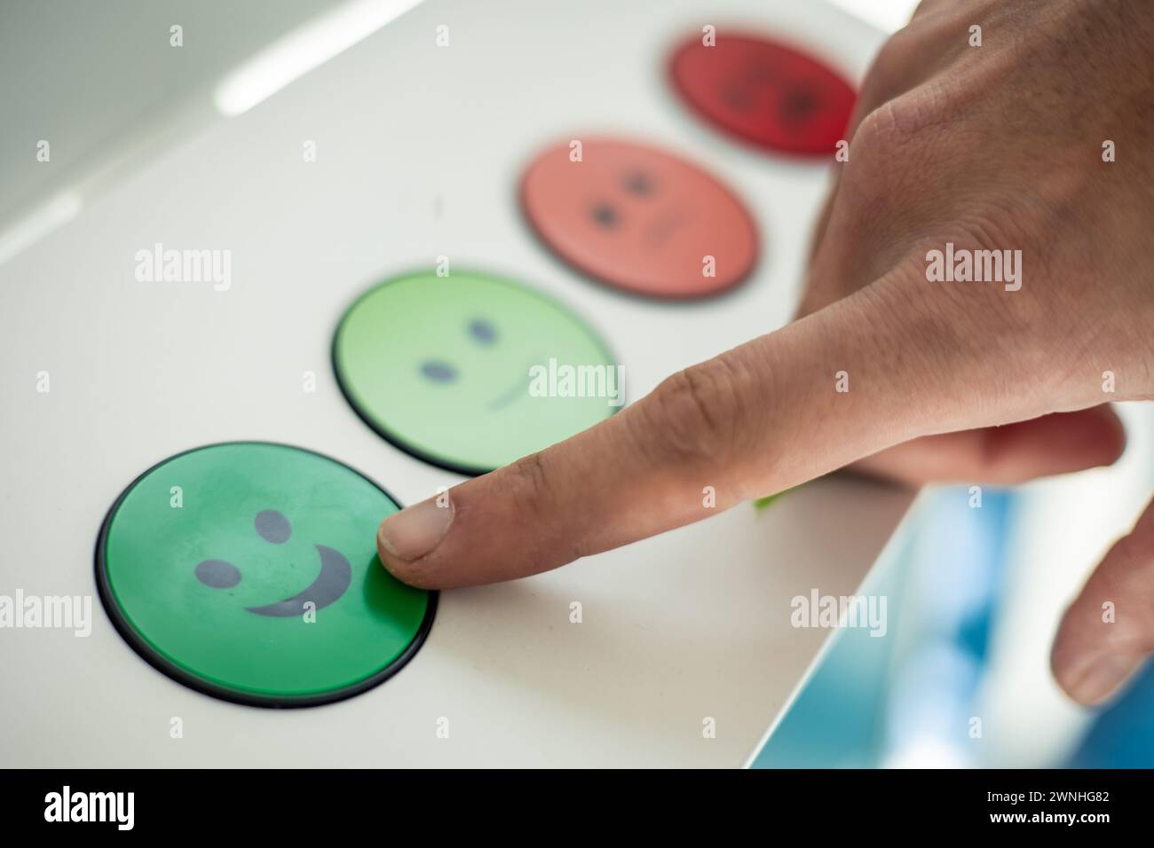 closeup hand pressing green happy face button on a rating panel Stock ...