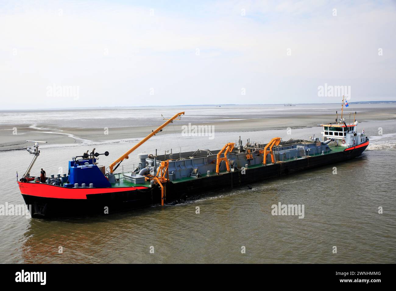 Dredger vessel in the Wadden Sea preventing the fairway from silting up ...