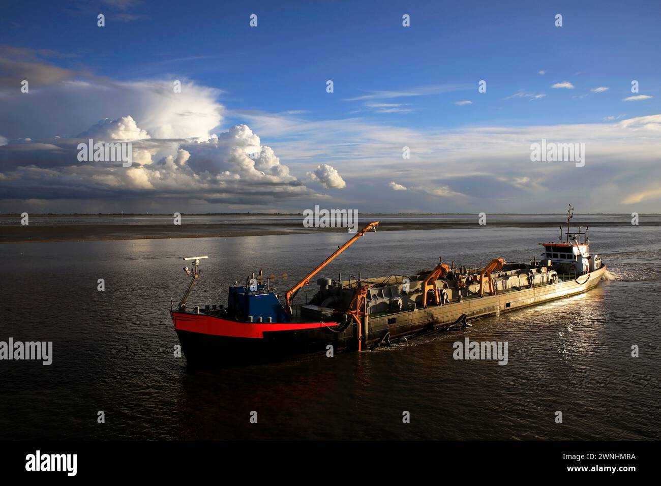 Dredger vessel in the Wadden Sea preventing the fairway from silting up ...