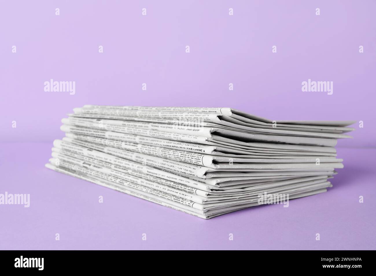 Stack of newspapers on light violet background. Journalist's work Stock ...